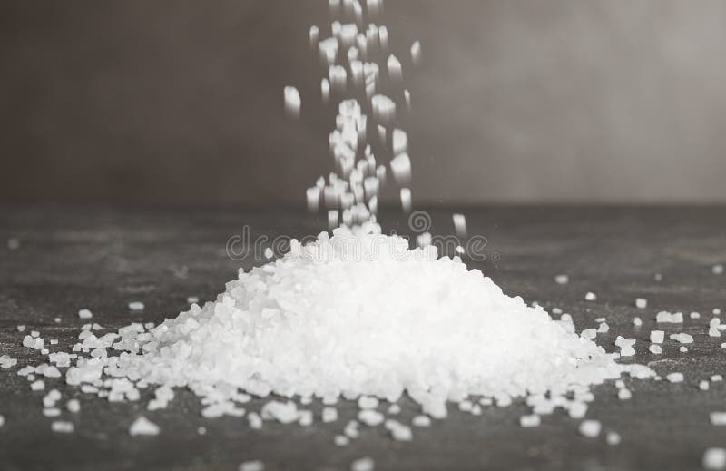 Natural Sea Salt Falling into Pile on Grey Table Stock Photo - Image of ...