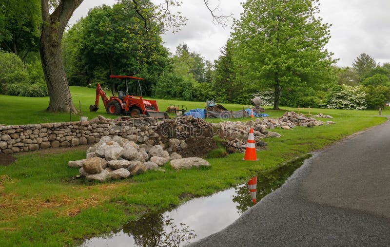 Natural Stone Wall Construction with Earth Mover at Roadside Stock ...