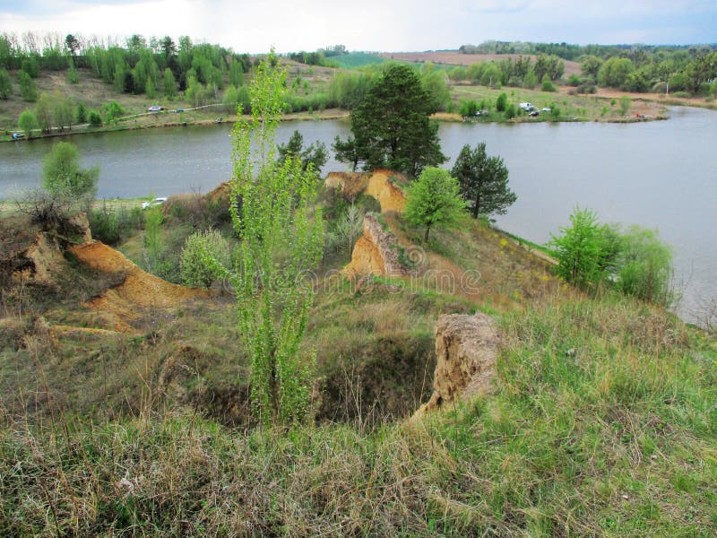 A Nature with a Lake on a Background of Yellow Rocks, Trees and Grass ...