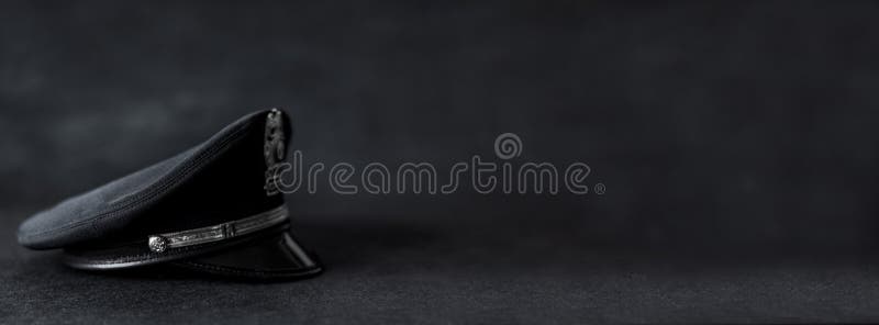 A Navy Blue Police Hat Cap in Front of a Navy Blue Background with Copy ...