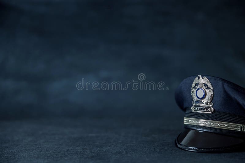 A Navy Blue Police Hat Cap in Front of a Navy Blue Background with Copy ...