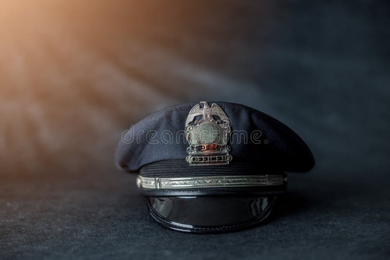 A Navy Blue Police Hat Cap in Front of a Navy Blue Background with Hazy ...