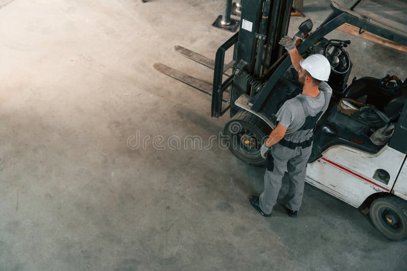 Near the Forklift, Top View. Young Factory Worker in Grey Uniform Stock ...