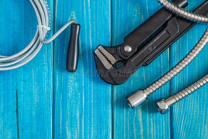 Necessary Set of Tools and Hose for Master Plumber on Blue Wooden ...