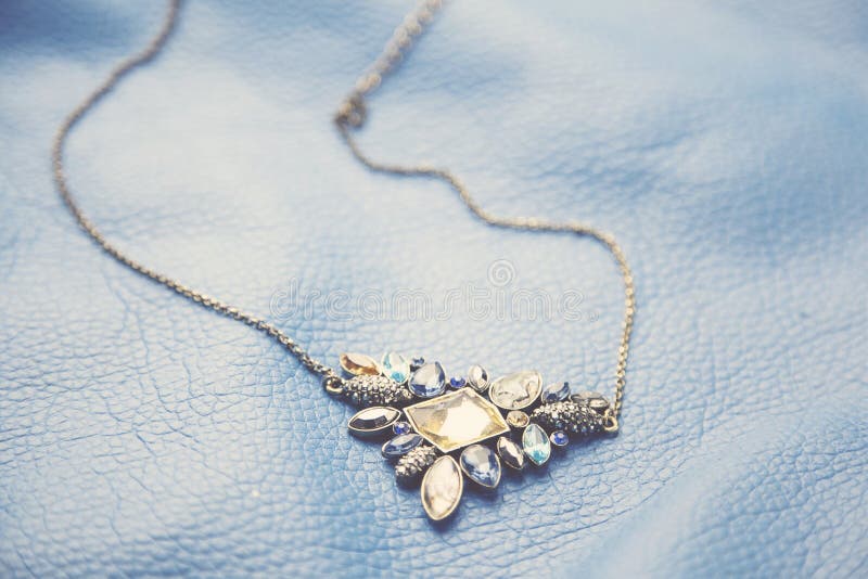 Necklace on blue texture stock image. Image of ball - 107916805
