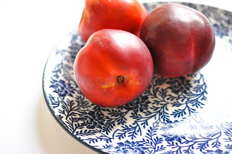 Nectarines on blue plate stock image. Image of background - 332402089
