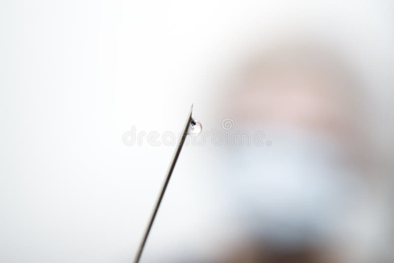 The Needle from the Syringe with a Drop on the End in the Background ...