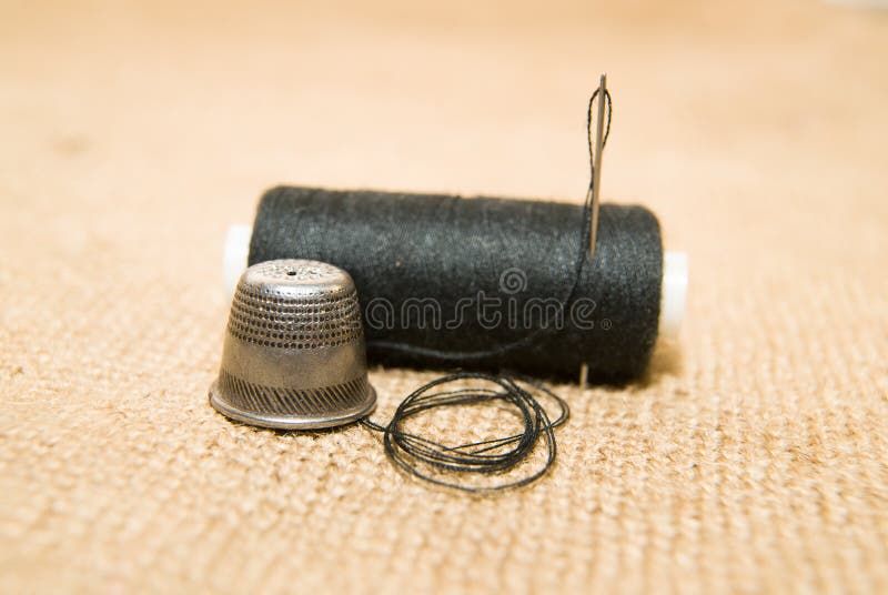 Needle, Thimble and Thread Spool on the Old Cloth Stock Photo - Image ...