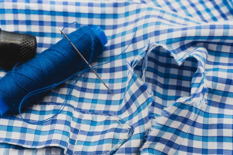 A Needle and Thread Lies on Torn or Holey Clothes. Shirt with a Hole ...