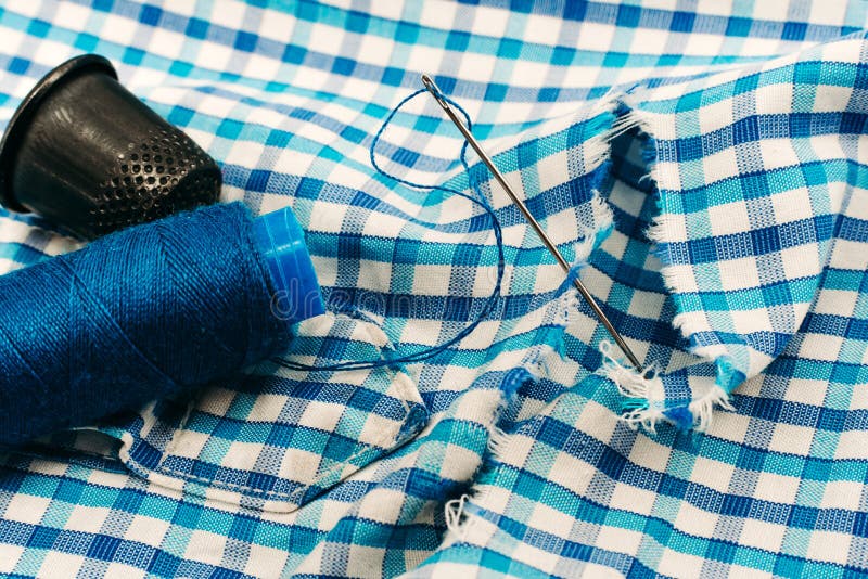 A Needle and Thread Lies on Torn or Holey Clothes. Shirt with a Hole ...