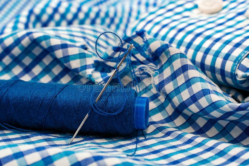 A Needle and Thread Lies on Torn or Holey Clothes. Shirt with a Hole ...