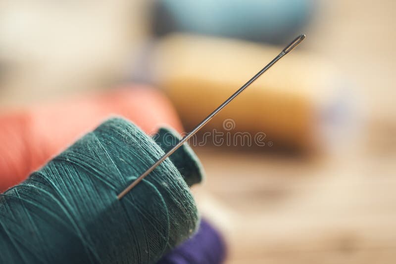 Needle with Threaded Yellow Thread Passing the Thread through a Black ...