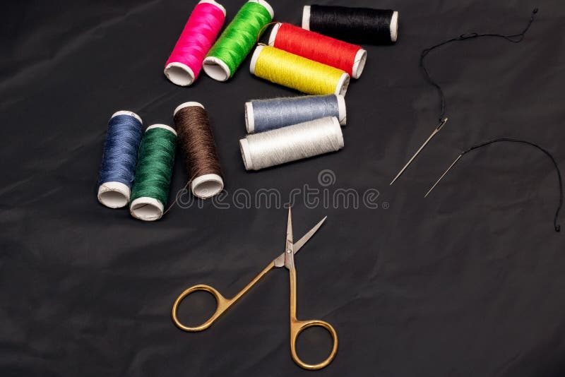 Needles, Scissors, Colored Threads on a Dark Fabric Stock Image - Image ...