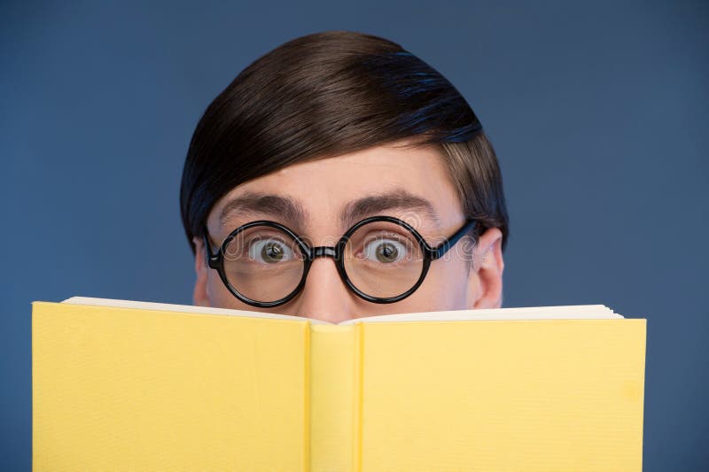 Nerd with Book. Young Nerd Man Holding a Book on Head while Stan Stock ...