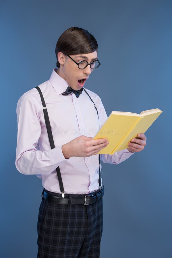 Nerd with Book. Young Nerd Man Holding a Book on Head while Stan Stock ...