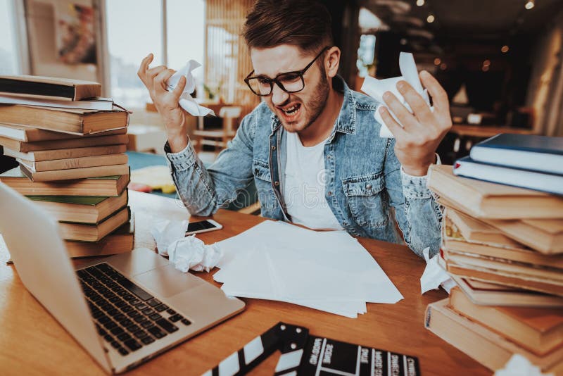Nervous Guy Sitting at Table with Stacks of Books Stock Photo - Image ...