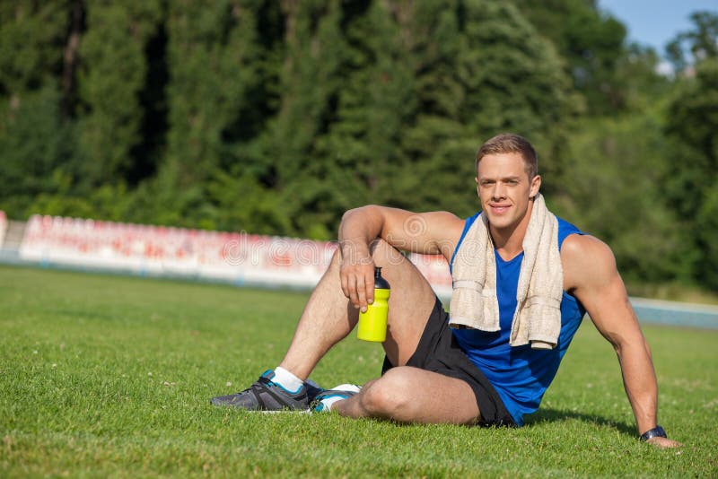 Junger Sportler, Der Draußen Wasserflasche Sitzt Und Hält Stockbild ...