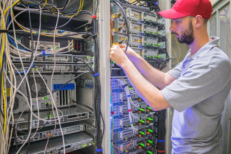 Network Engineer Switches Power Cables in the Server Room Rack. the ...
