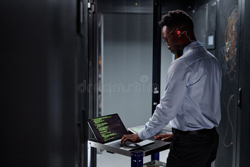 Network Engineer Using Laptop while Setting Up Servers in Data Center ...