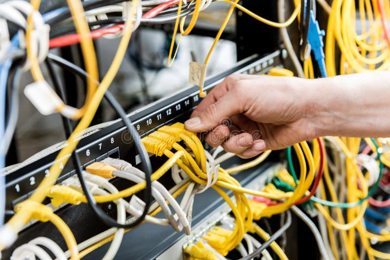 Network Engineer Working in Server Room. Connecting Network Cables To ...