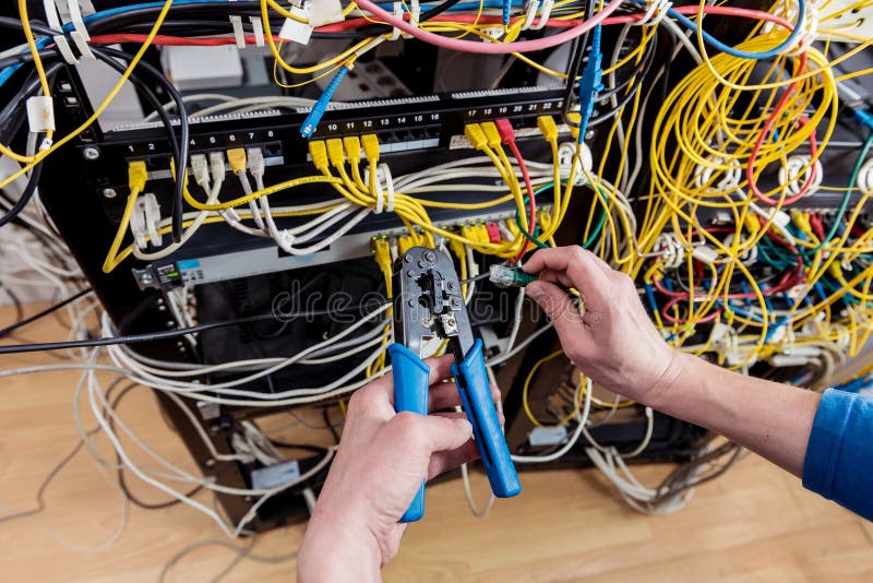 Network Engineer Working in Server Room. Connecting Network Cables To ...
