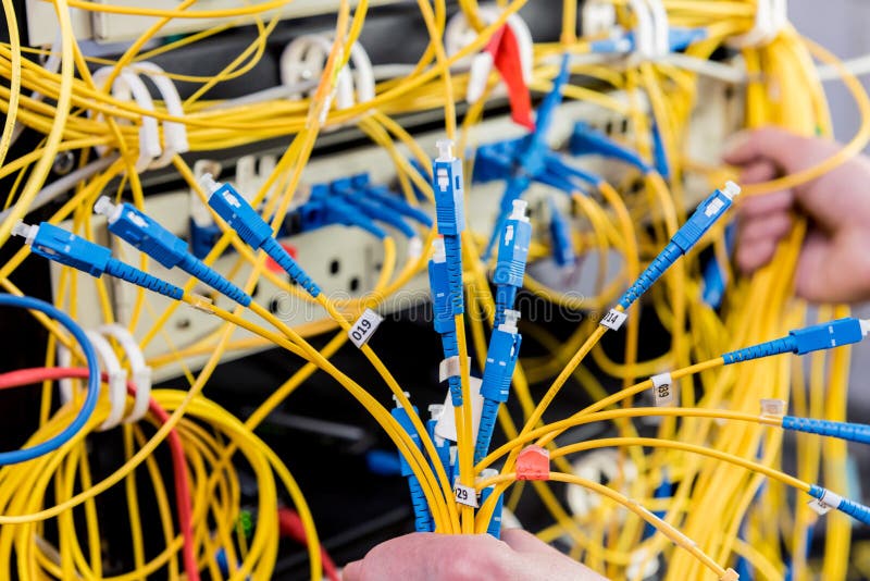 Network Engineer Working in Server Room. Connecting Network Cables To ...