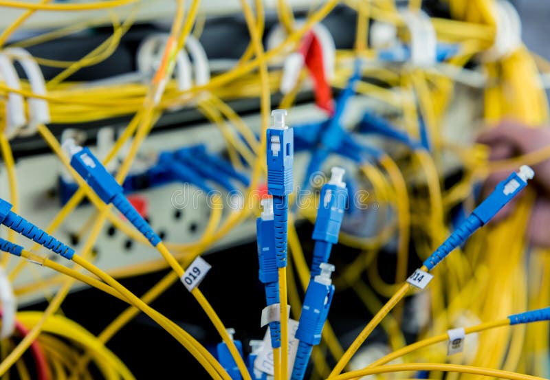 Network Engineer Working in Server Room. Connecting Network Cables To ...