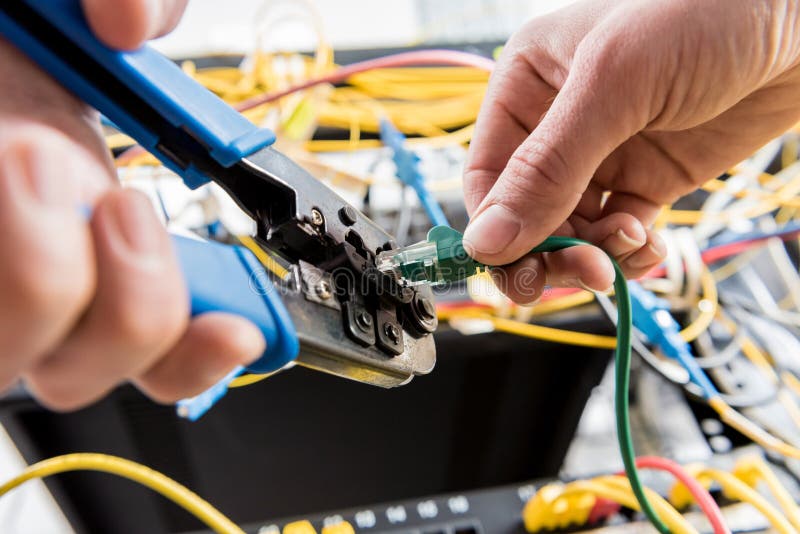 Network Engineer Working in Server Room. Connecting Network Cables To ...