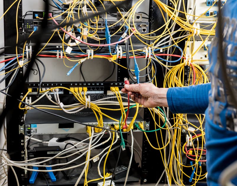 Network Engineer Working in Server Room. Connecting Network Cables To ...