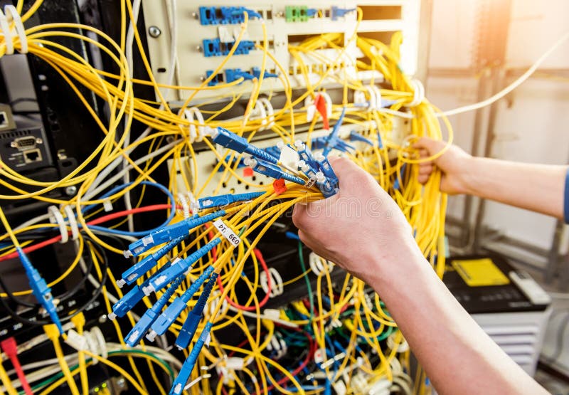 Network Engineer Working in Server Room. Connecting Network Cables To ...