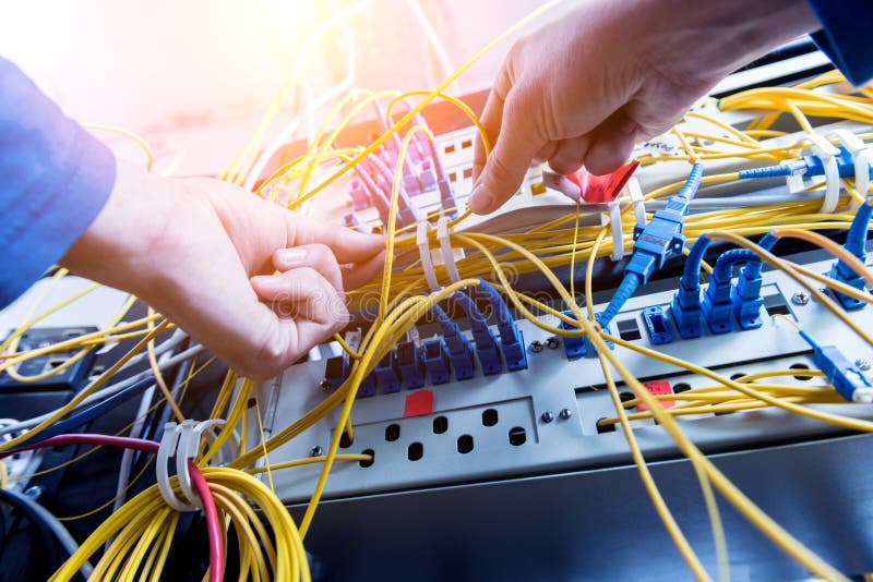 Network Engineer Working in Server Room. Connecting Network Cables To ...