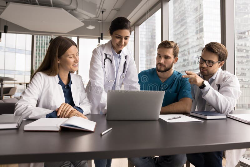Enthusiastic Polyethnic Doctors Team Hold Conversation Looking at ...