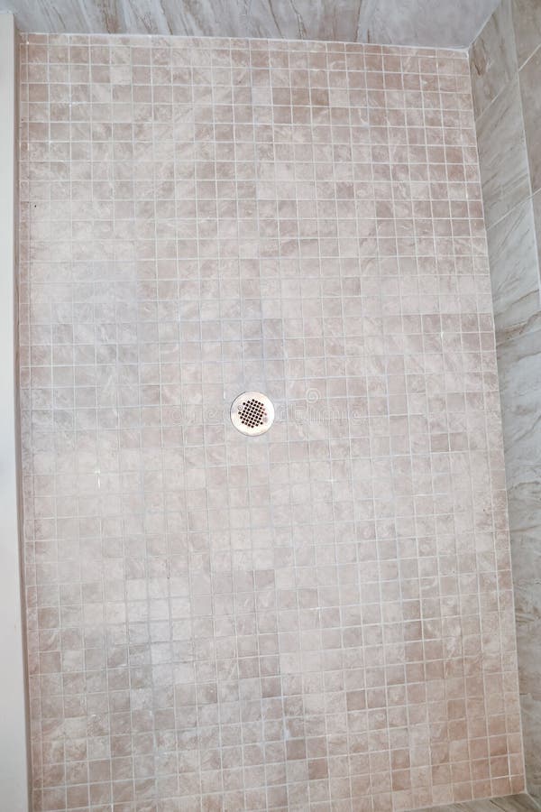 A Neutral Light Beige Square Tile Shower Floor with a Silver Metal ...