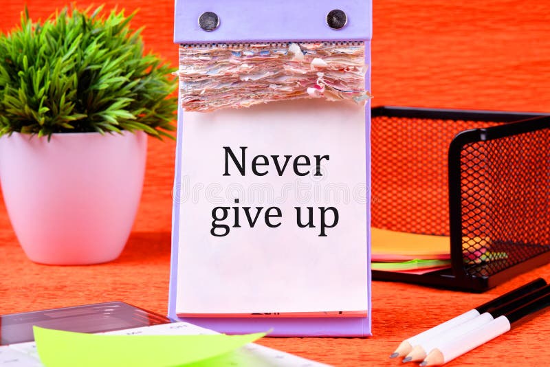 Never Give Up Words it is Written on a Desktop Calendar with Loose ...