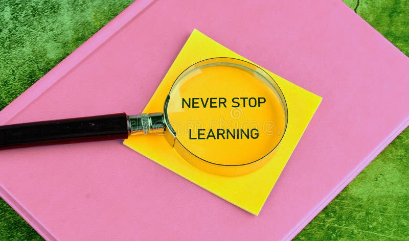 Never Stop Learning Written on a Yellow Sticker through a Magnifying ...