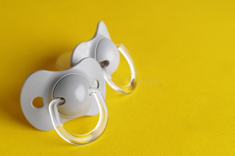 New Baby Pacifiers on Yellow Background. Space for Text Stock Image ...