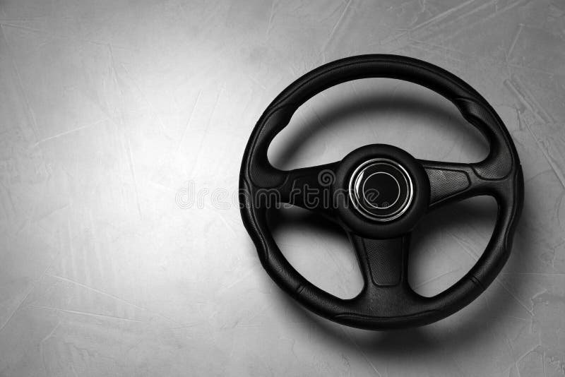 New Black Steering Wheel on Grey Table, Top View. Space for Text Stock ...