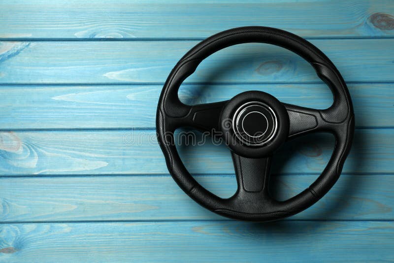 New Black Steering Wheel on Light Blue Wooden Table, Top View. Space ...