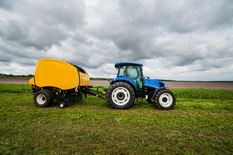 New Blue Tractor with Baler in Motion at Field Stock Photo - Image of ...