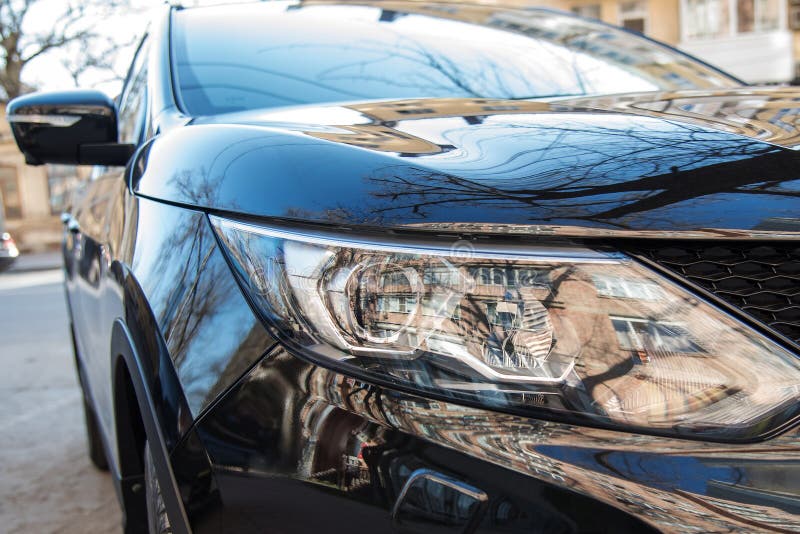 New Clean Front Headlight of a Black Car with Street Reflection. Stock ...