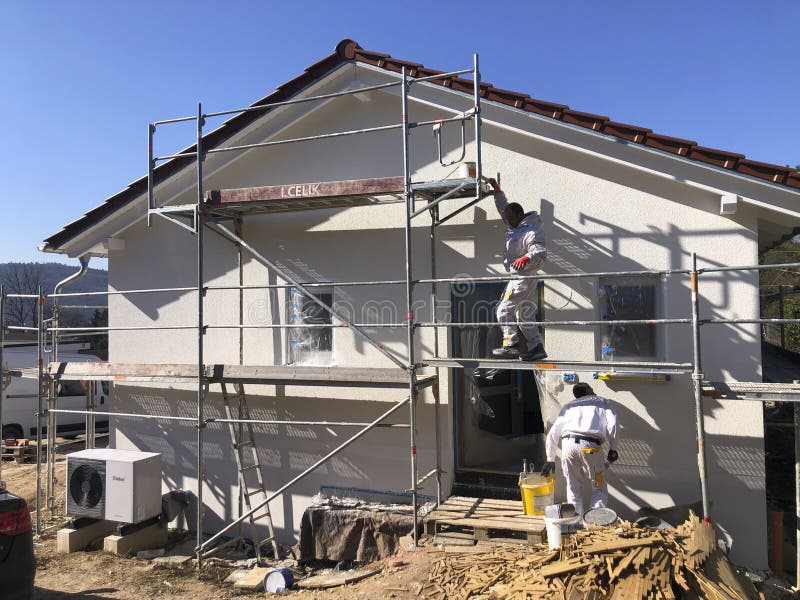 New Construction with Finished Base Plaster, Worker on Scafffold ...
