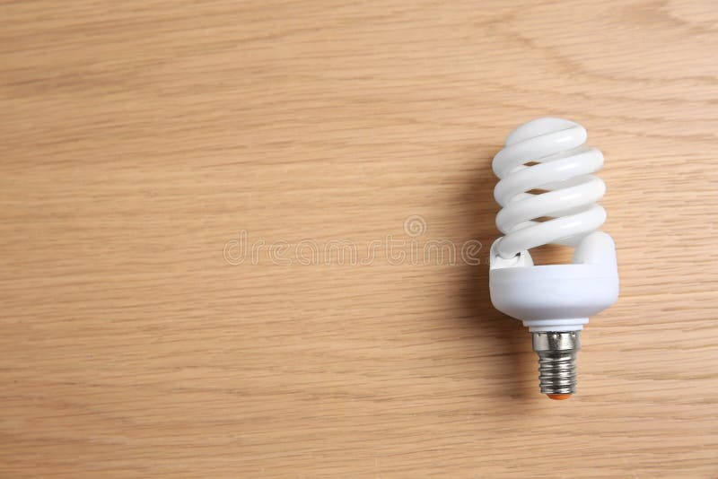 New Fluorescent Light Bulb on Wooden Table, Top View. Space for Text ...