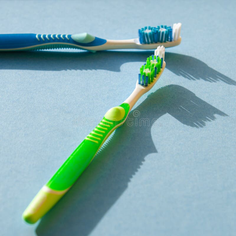 New Multicolored Toothbrushes with Sharp Shadows Lie on a Blue ...