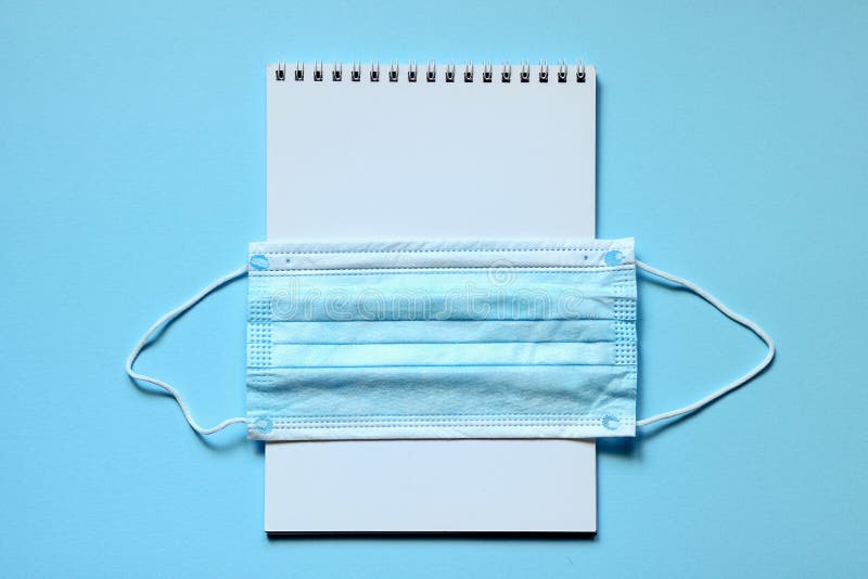 New Normal Concept with a Blue Face Mask and White Blank Notebook Page ...