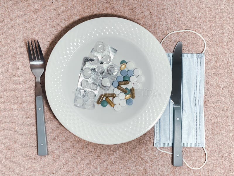 New Normal - Medical Pills in a Plate with a Fork, a Knife and a Face ...