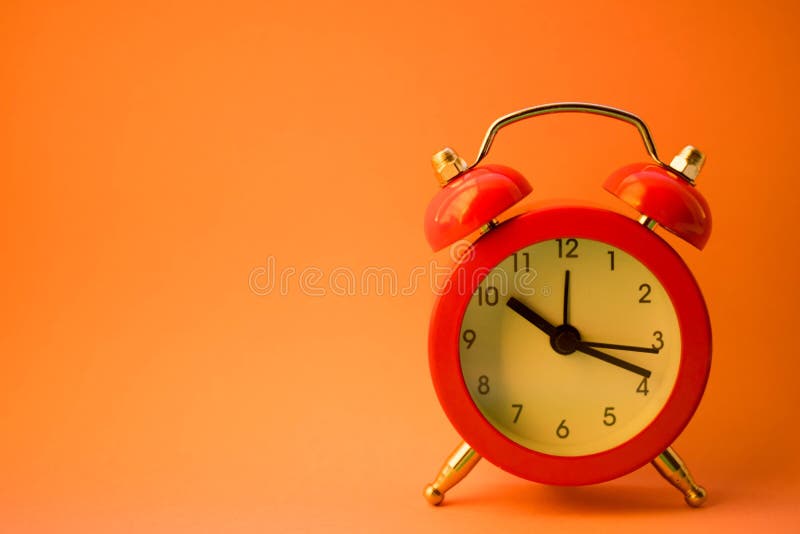 New Red Round Clock on Orange Table, Side View Copy Space Stock Photo ...