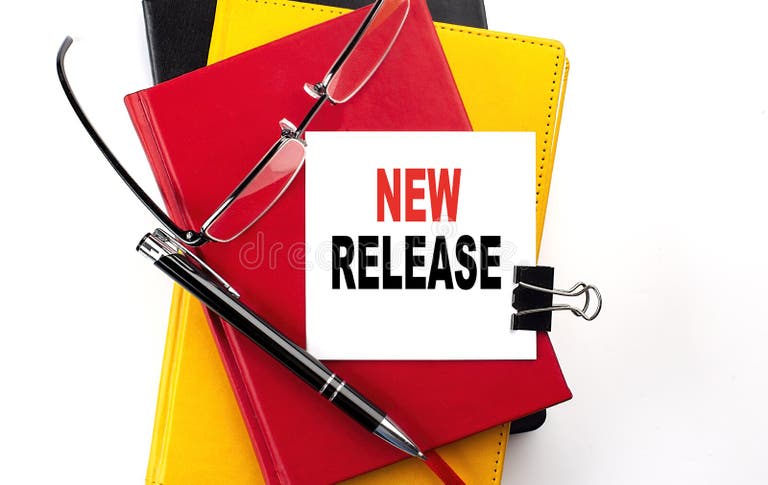 NEW RELEASE Text Written on a Sticky on Colorful Notebooks Stock Photo ...