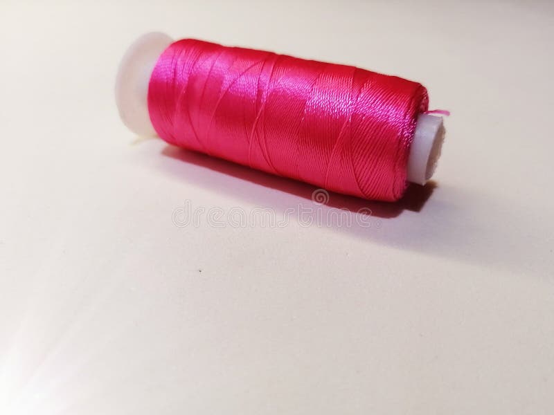 Spool of Silk Pink Thread on a Blue Background Stock Photo - Image of ...