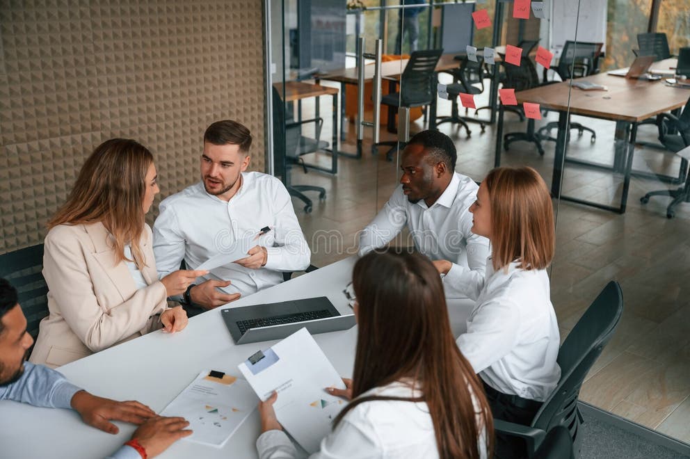New Technology for the Project. Talking, Sitting by Table Stock Photo ...