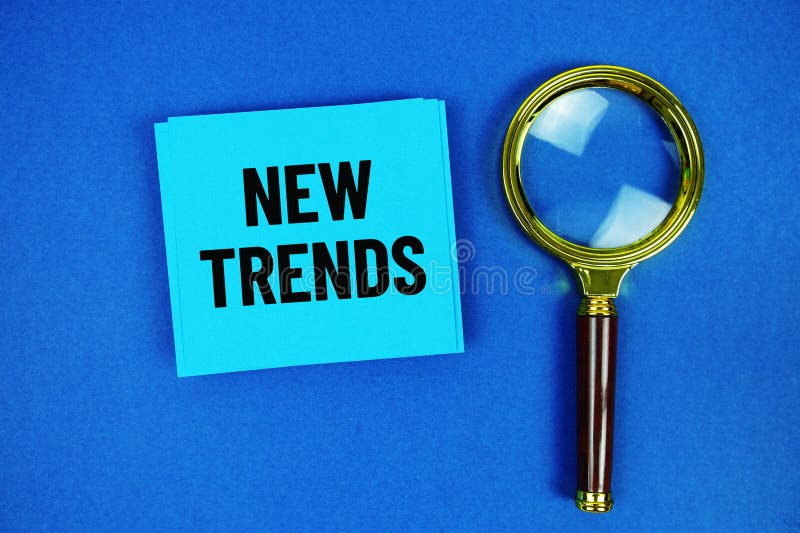 New Trends Text on Sticky Note with Magnifying Glass on Blue Background ...